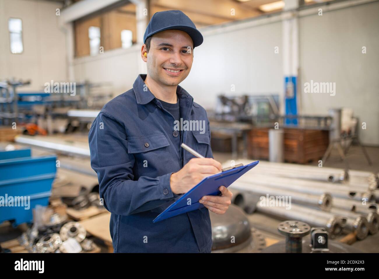 Industrial worker writing on a document in a factory Stock Photo - Alamy
