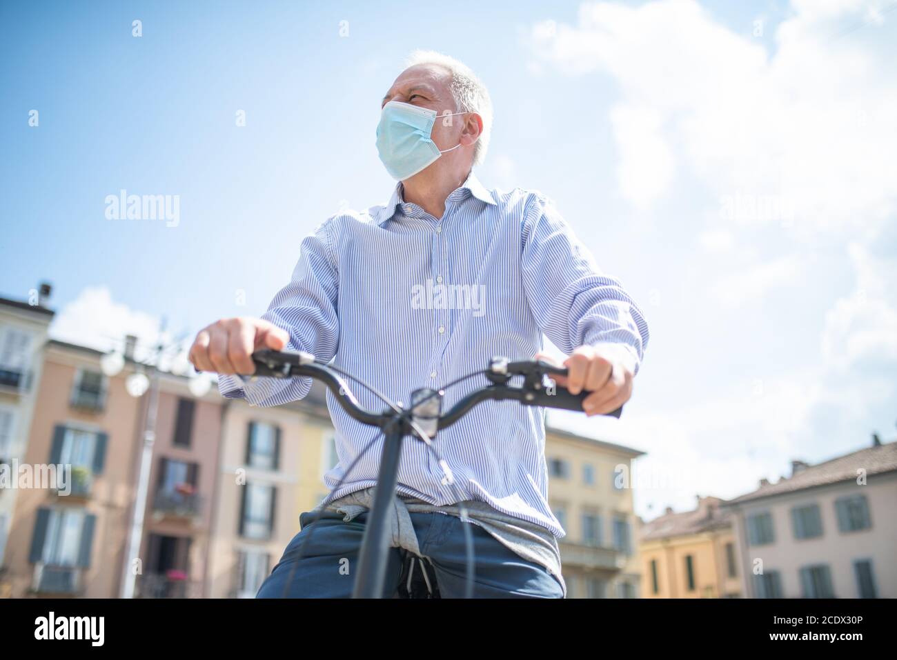 Man riding his bike in a city square Stock Photo - Alamy