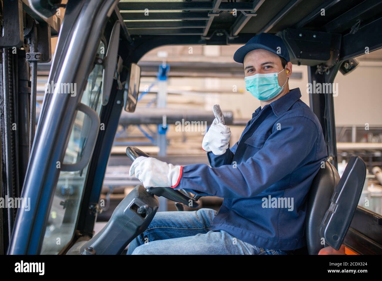 Worker using a forklift, driver at work in an industrial factory Stock ...