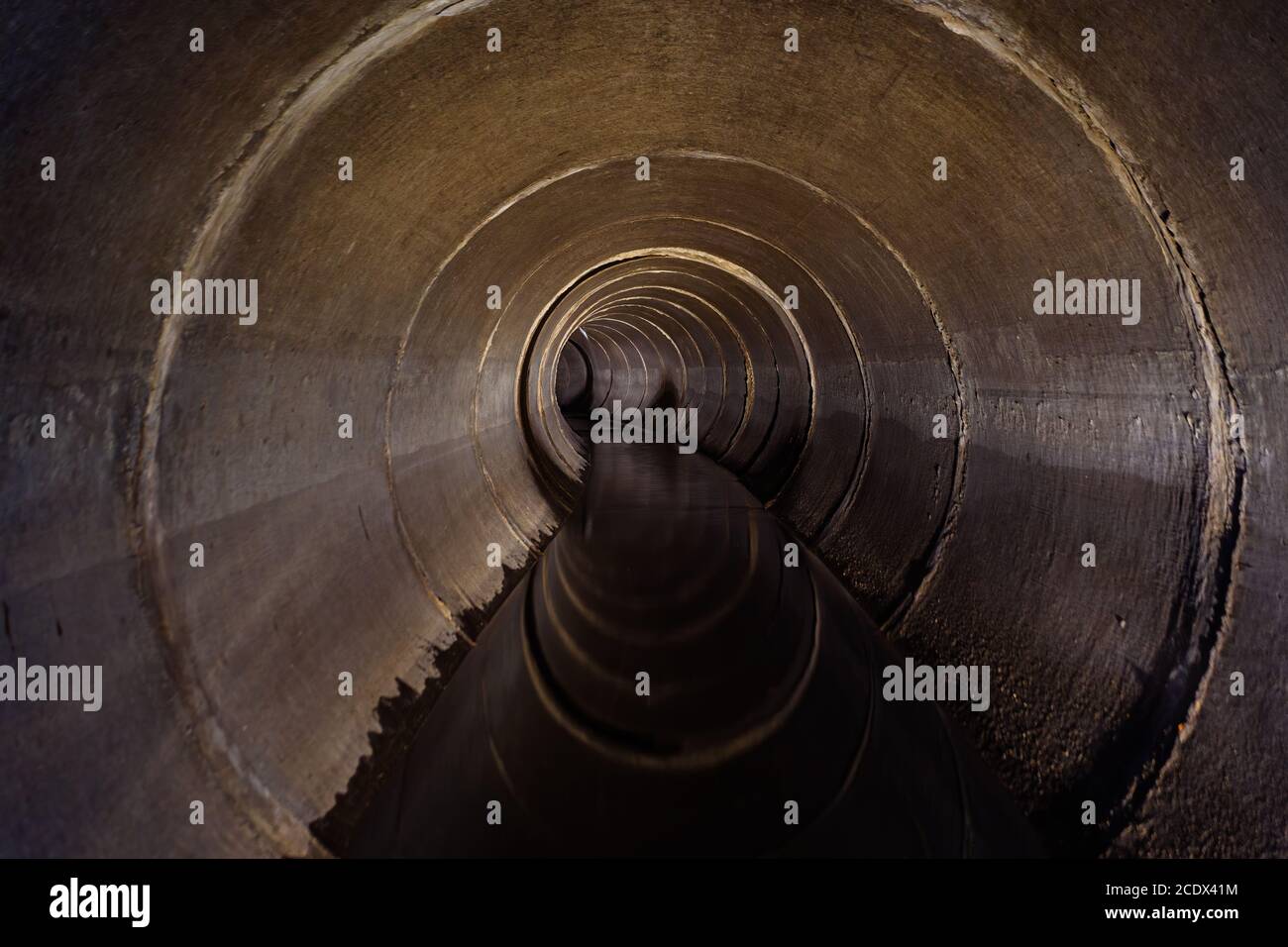 Flooded round sewer tunnel with water reflection Stock Photo - Alamy