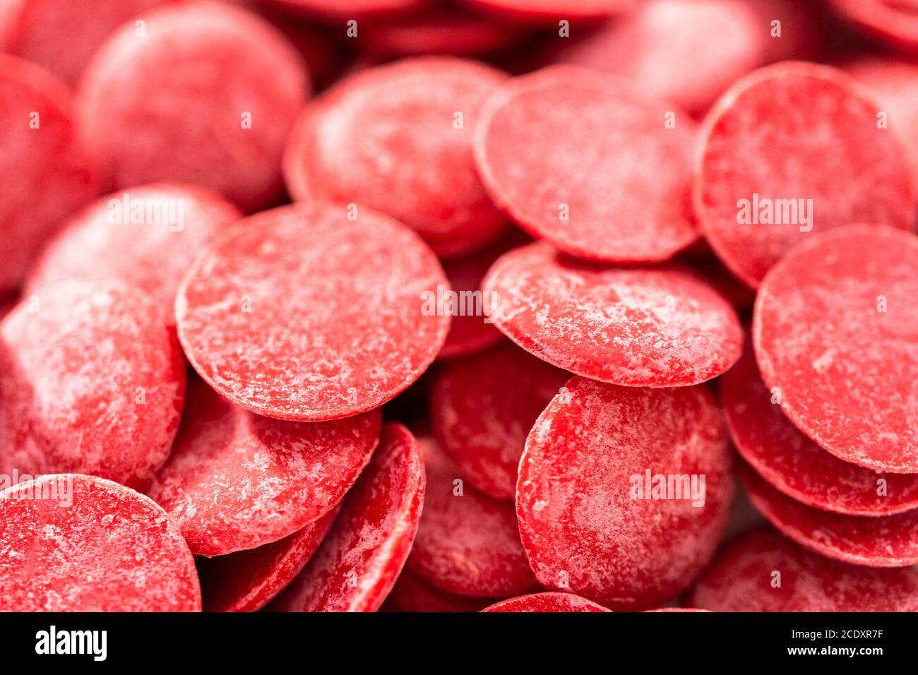 Red round chocolate chips for melting chocolate shapes on a white ...