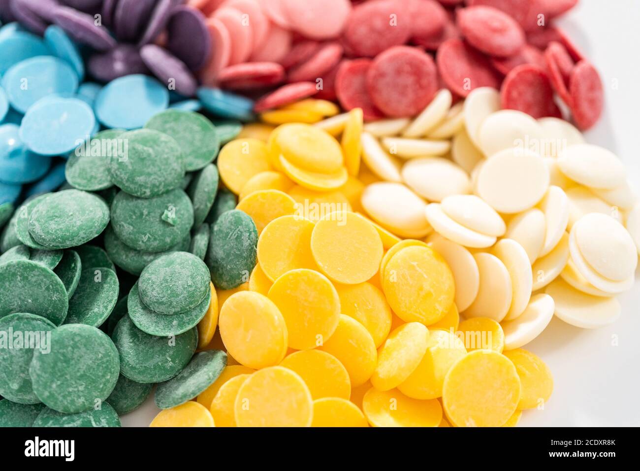 Rainbow colors of round chocolate chips for melting chocolate shapes on ...