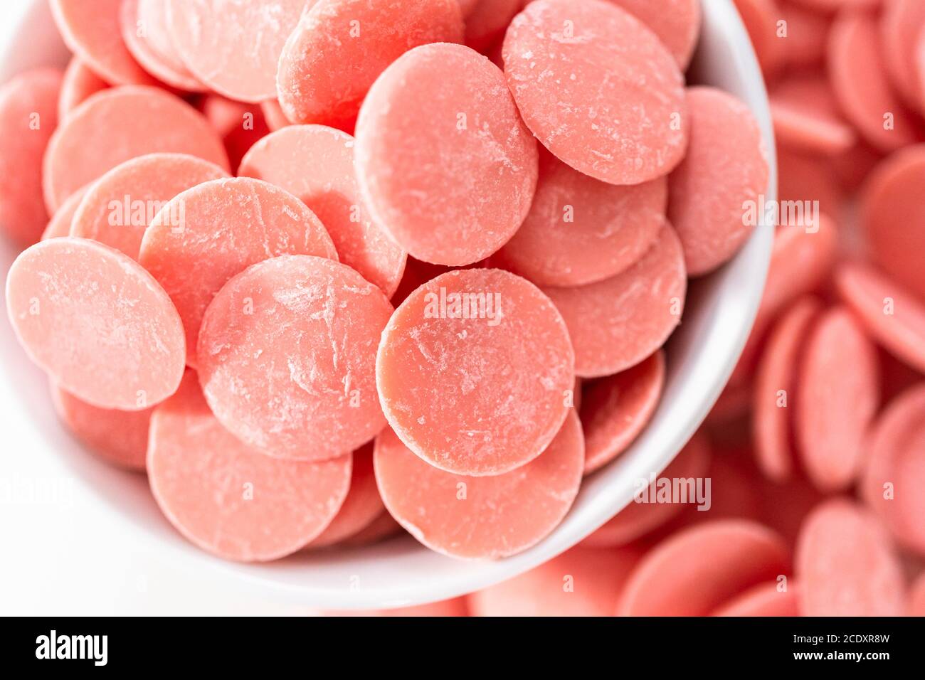 Pink round chocolate chips for melting chocolate shapes on a white ...