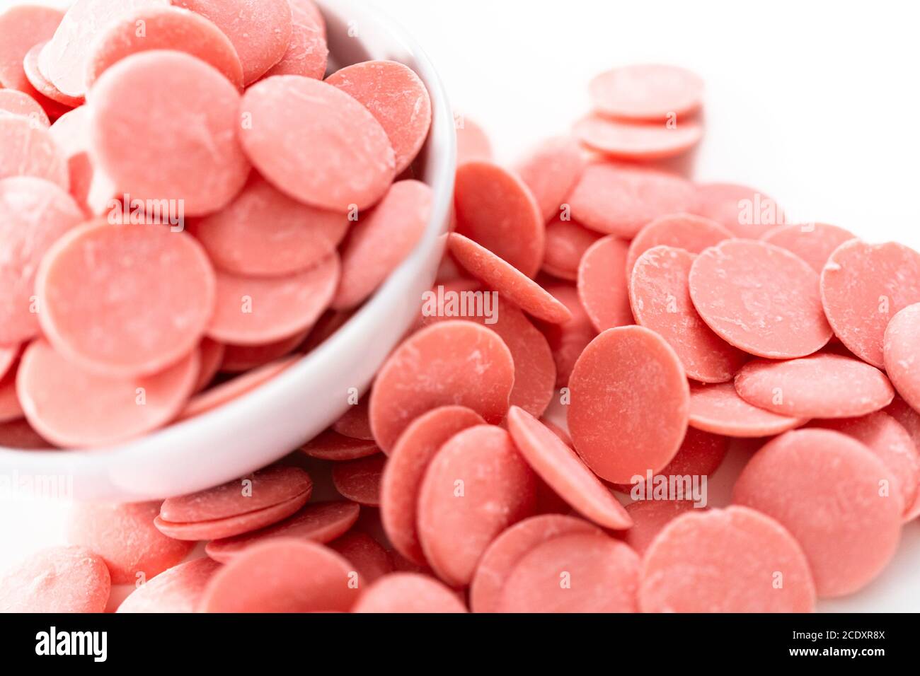 Pink round chocolate chips for melting chocolate shapes on a white ...