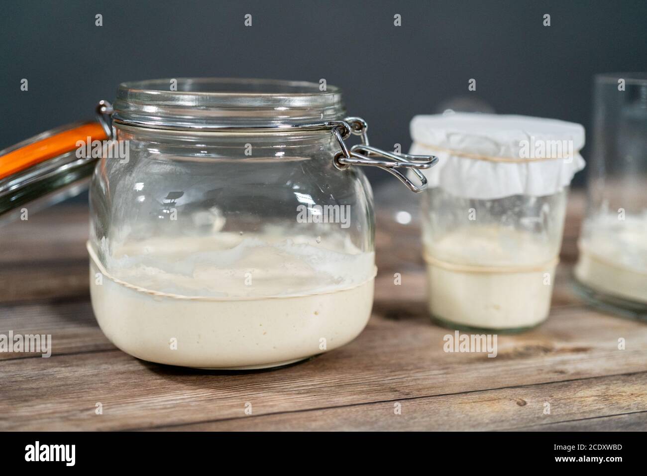 Feeding sourdough starter in a glass mason jar for baking artisan bread ...