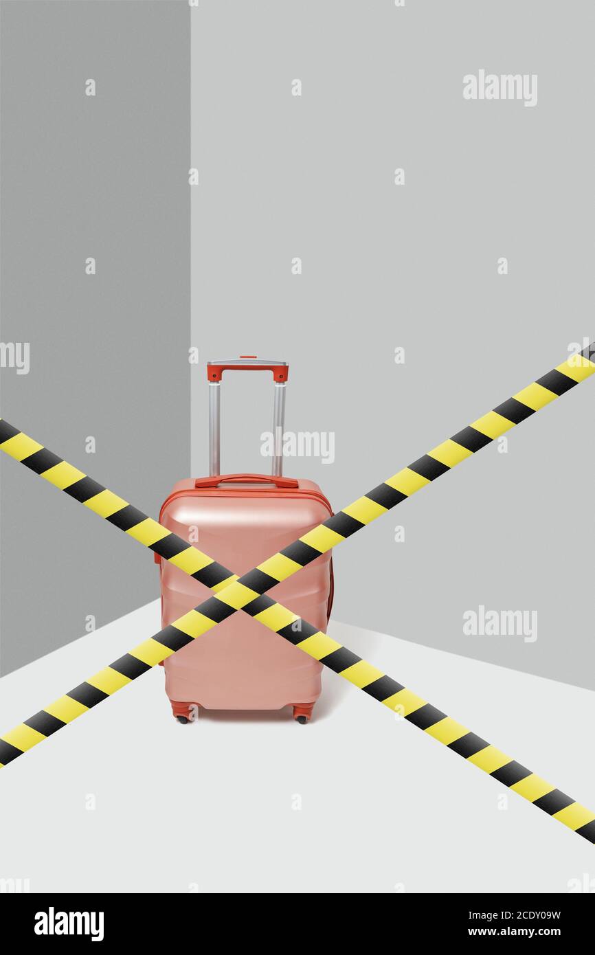 Travel suitcase behind crossed forbidden lines in the corner of gray ...