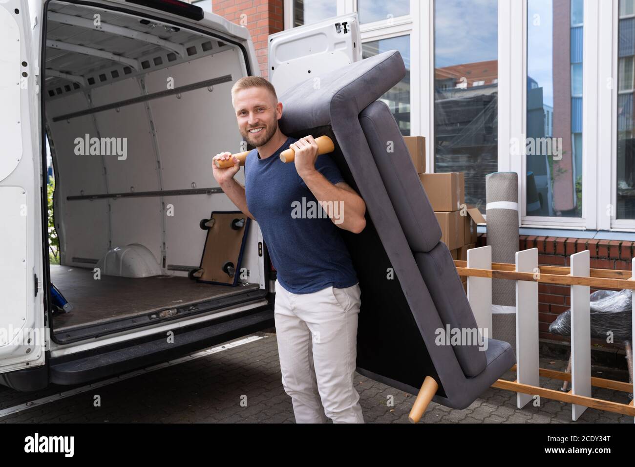 Man Lifting Sofa Or Couch Furniture. Moving Home Stock Photo - Alamy