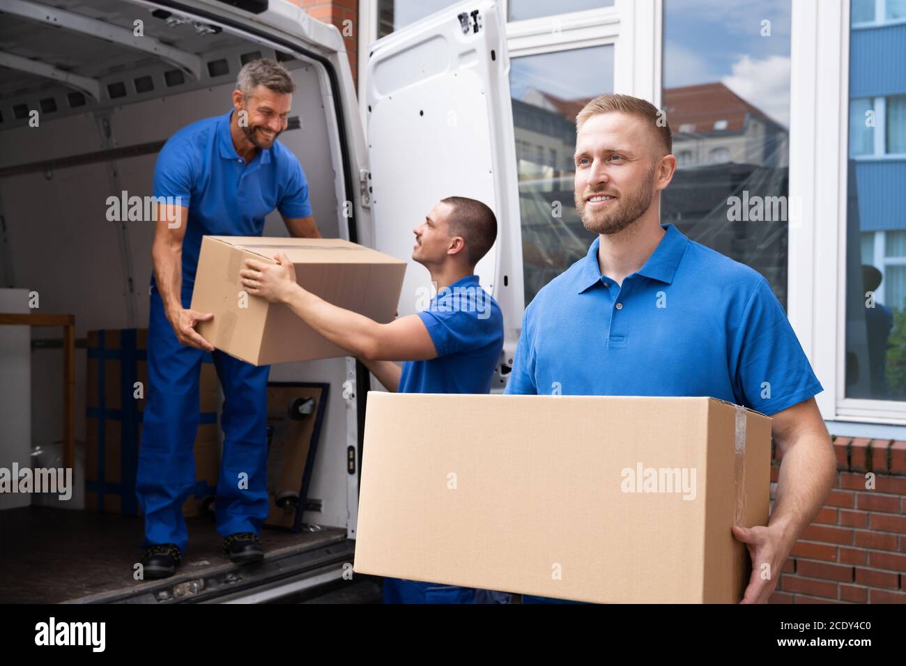 Truck Movers Loading Van Carrying Boxes And Moving House Stock Photo ...