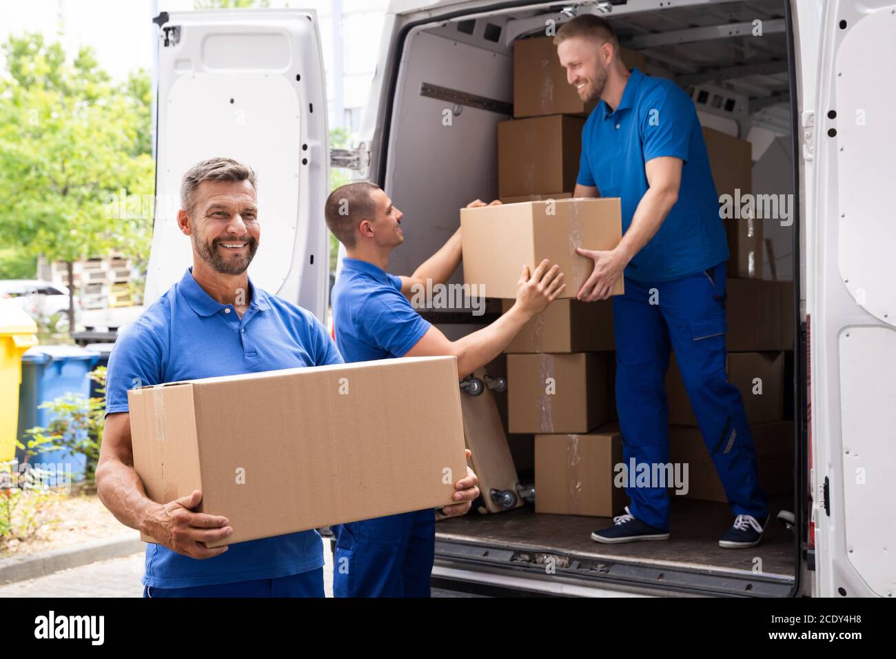 Delivery man carrying boxes on a hand truck hi-res stock photography ...