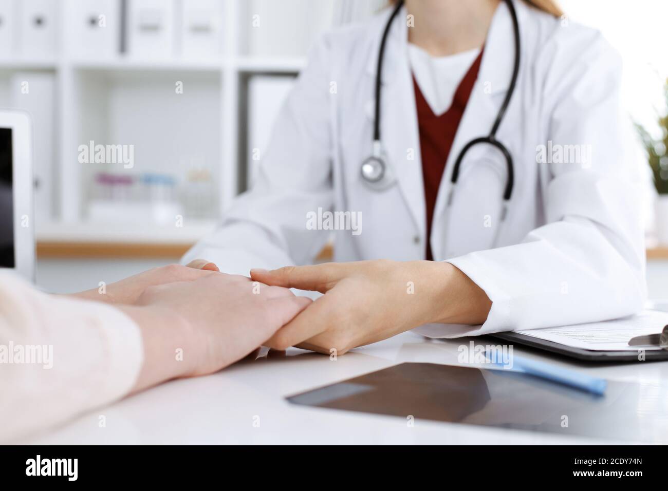 Hands of unknown woman-doctor reassuring her female patient, close-up ...