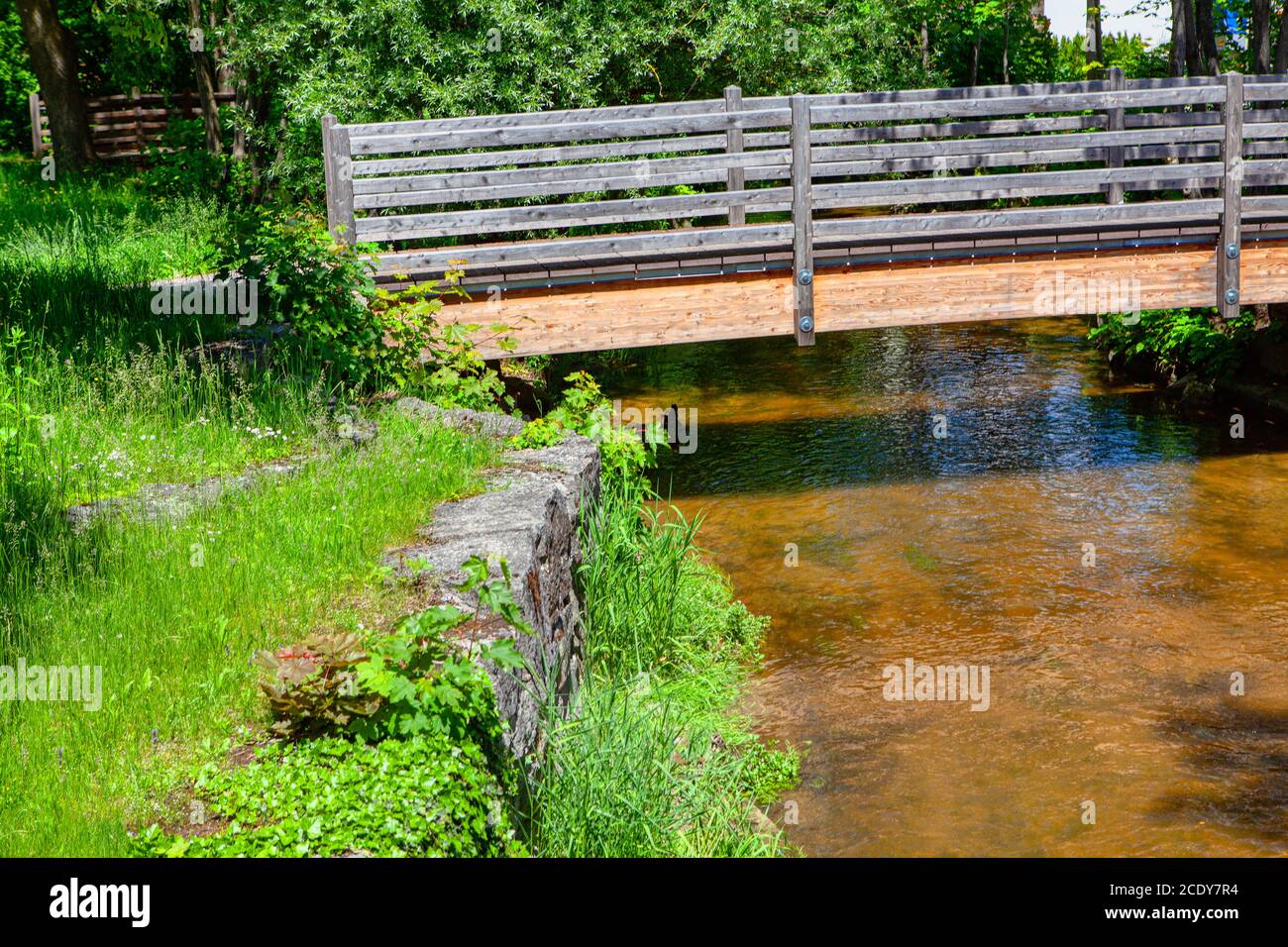 Wooden footbridge over a small river Stock Photo - Alamy