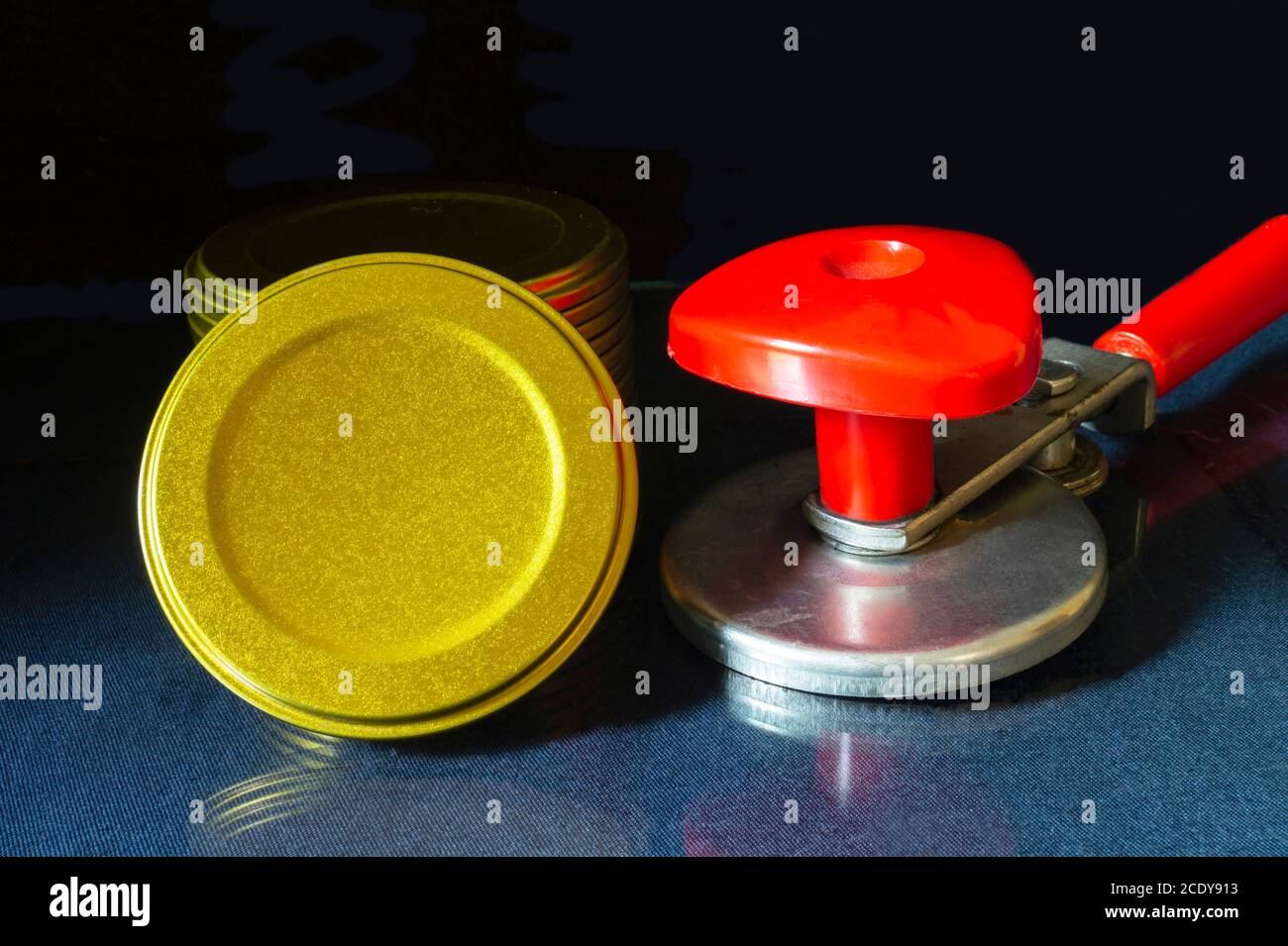 Rolling machine, lid of jar rests upon table close-up gilded colour ...
