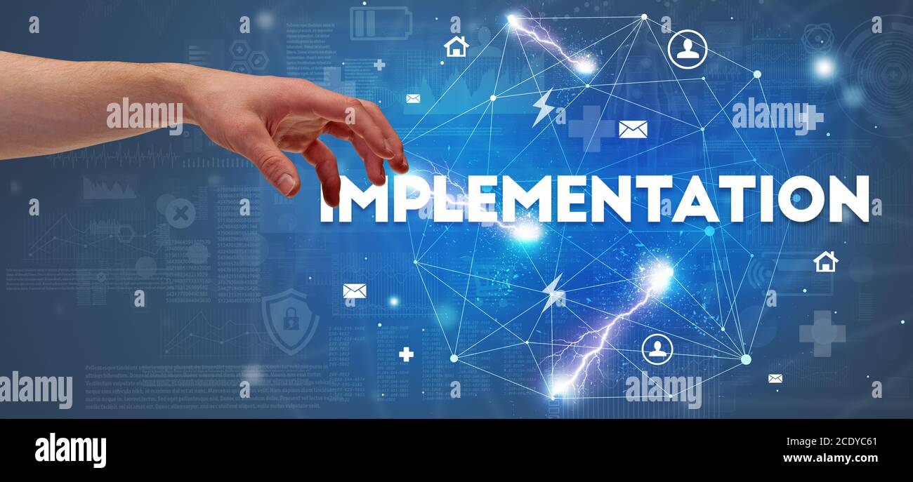 Hand pointing at IMPLEMENTATION inscription, modern technology concept ...