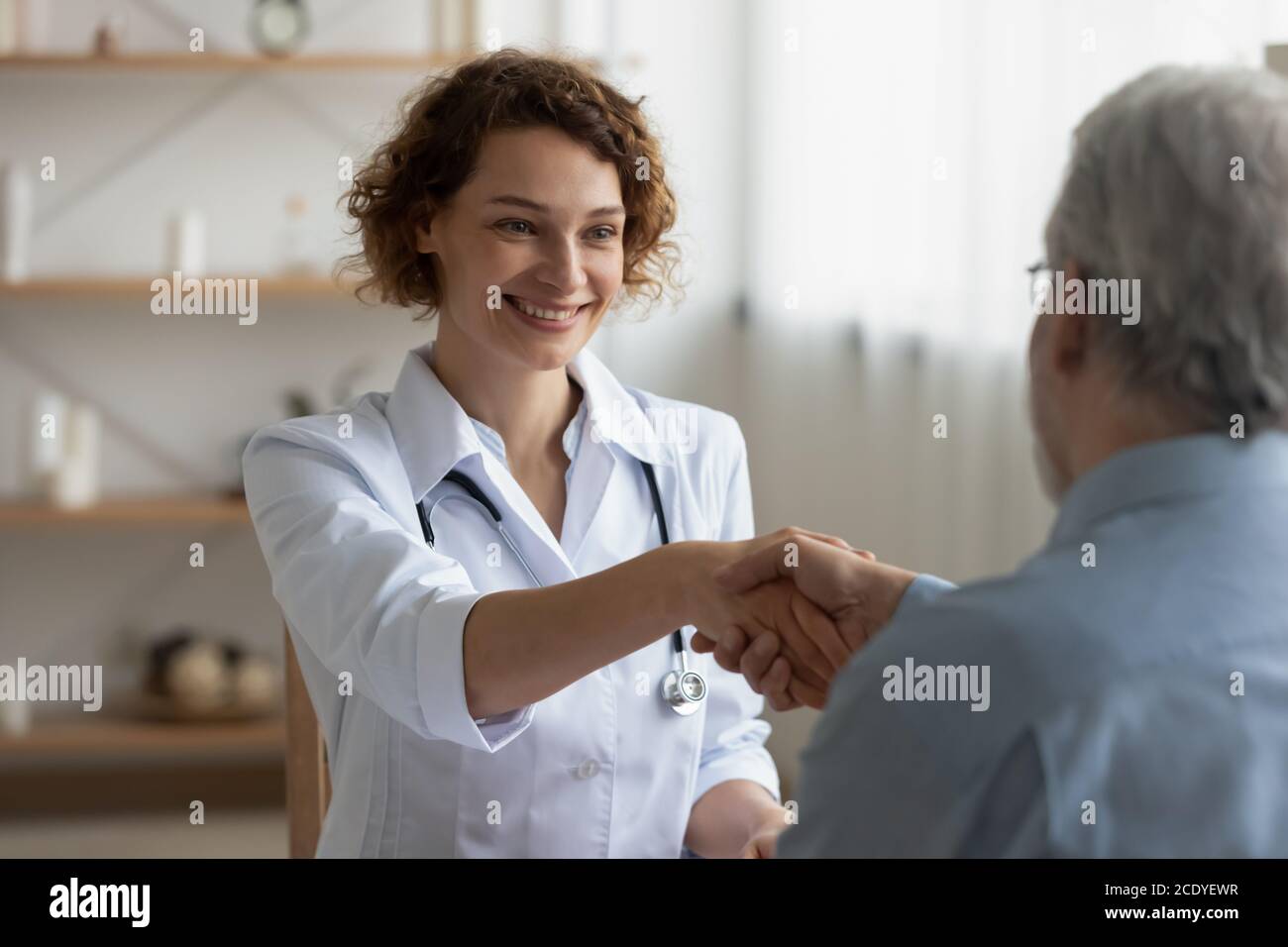 Smiling friendly doctor shaking mature patient hand at meeting Stock ...