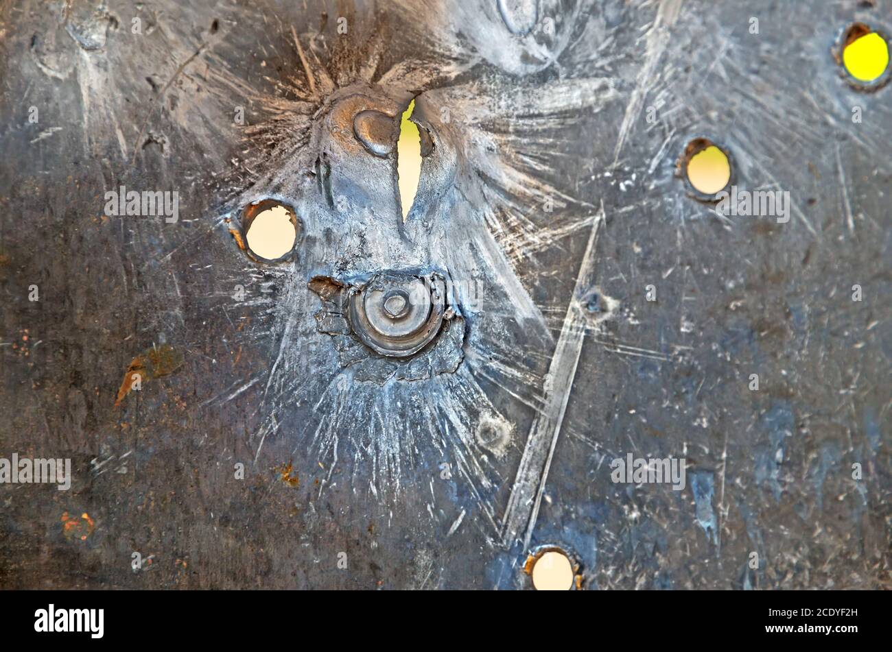 Bullet holes on chunk of metal after testing strength of armor with ...