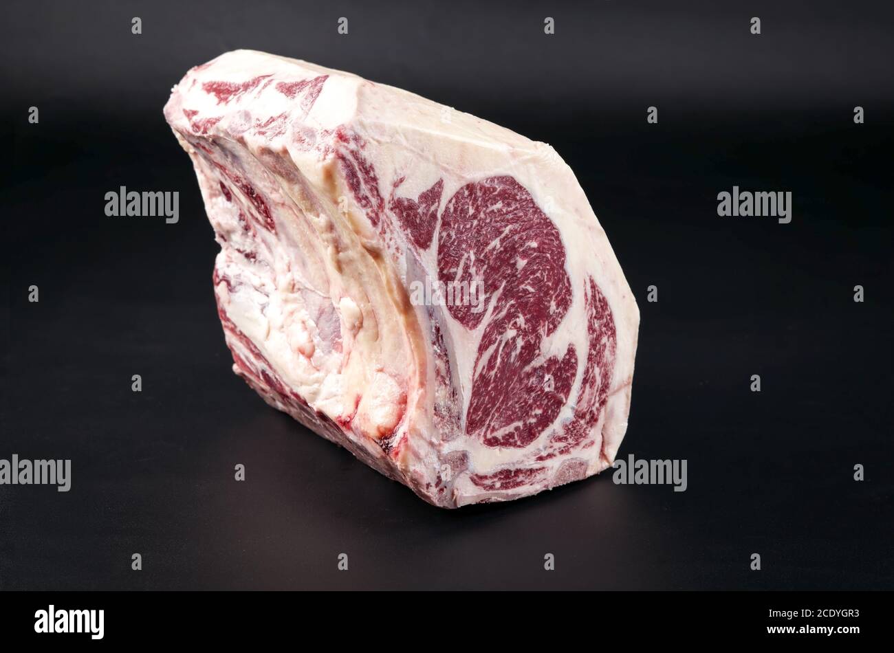 Raw dry aged wagyu cote de boeuf beef block as closeup on black ...