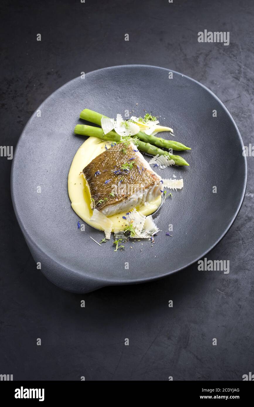 Traditional fried skrei cod fish filet with green asparagus tips and ...