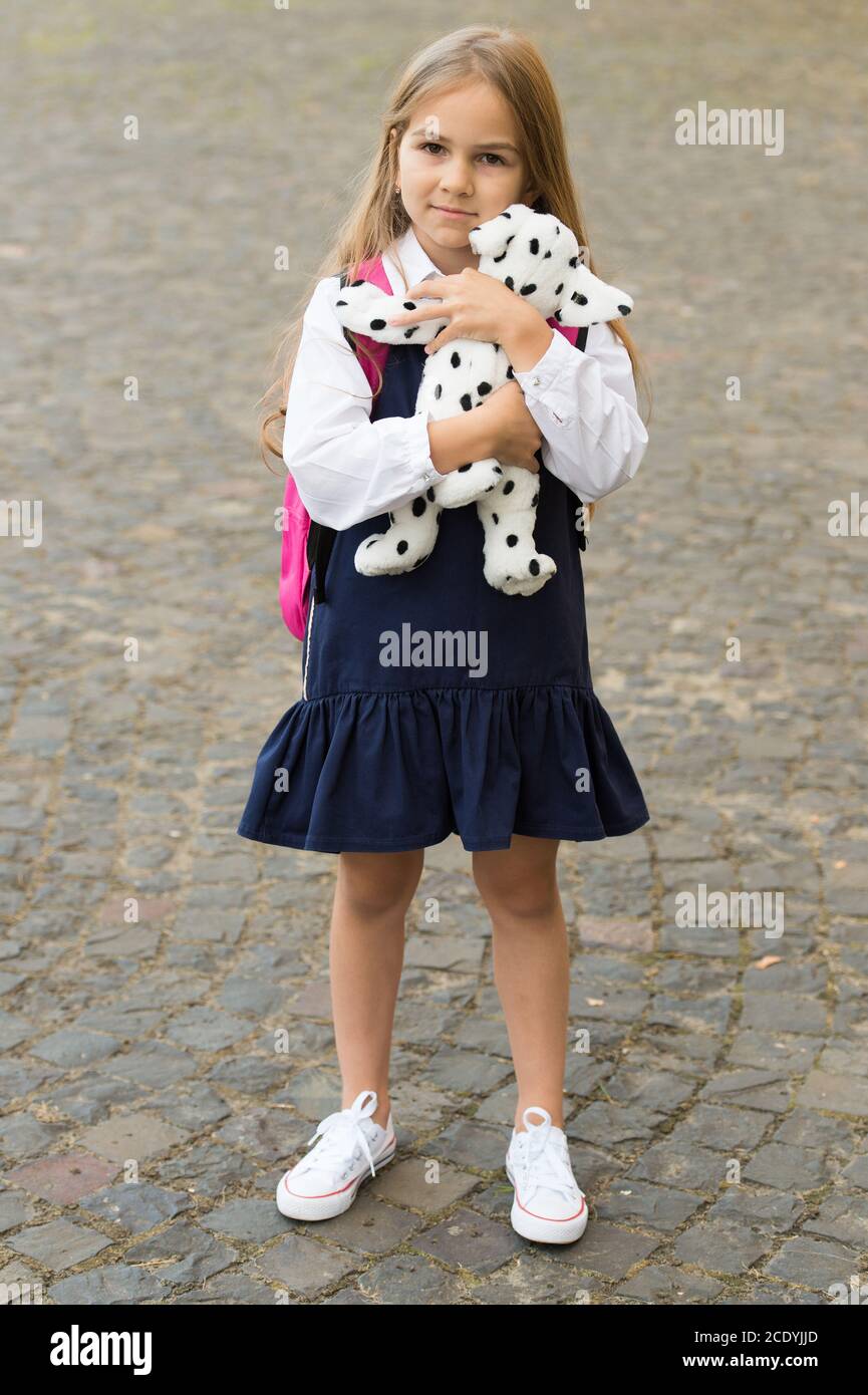 Learning starts with playing. Little child hold toy dog outdoors ...