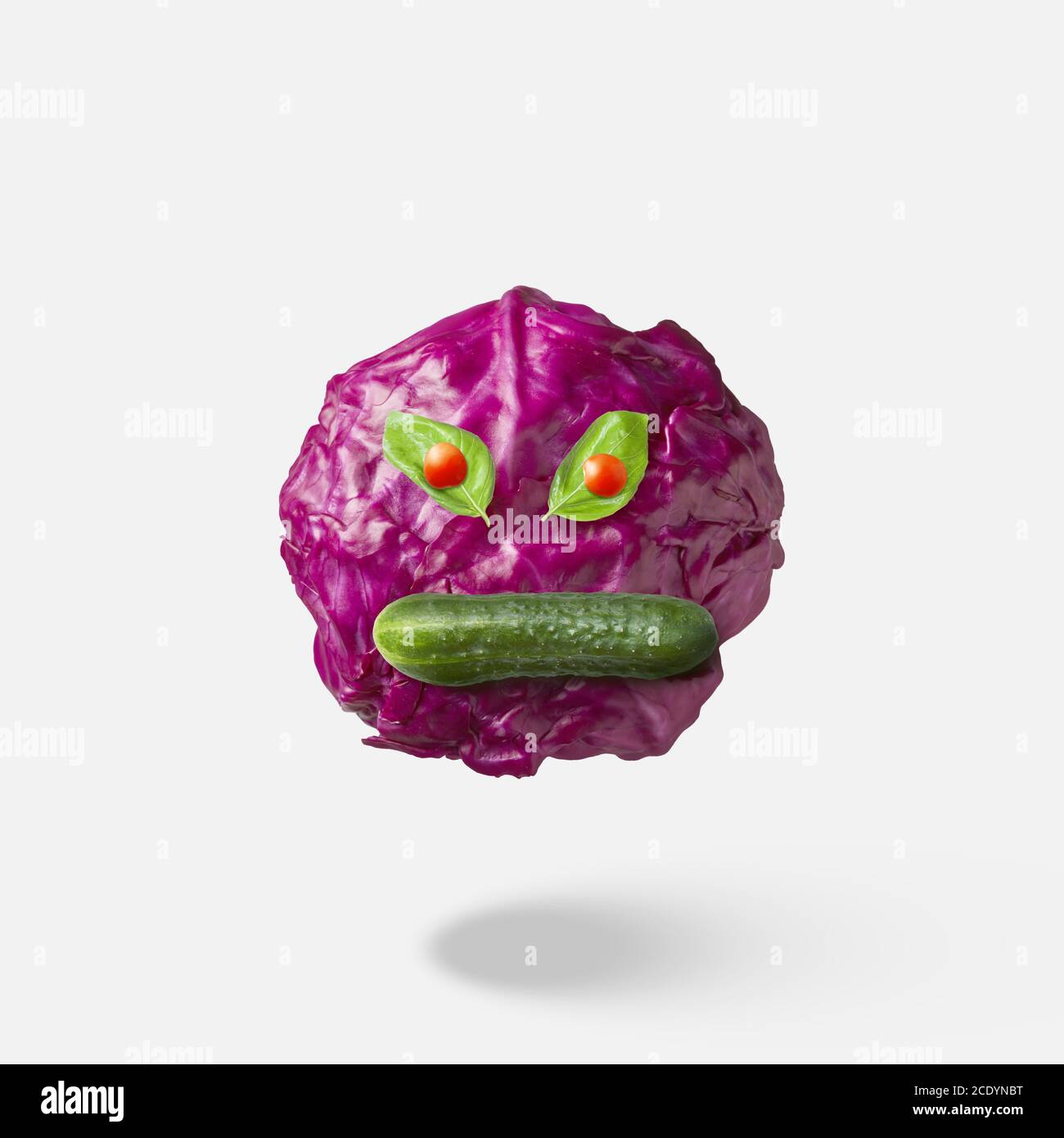 Angry face made from fresh natural vegetables flying above background ...