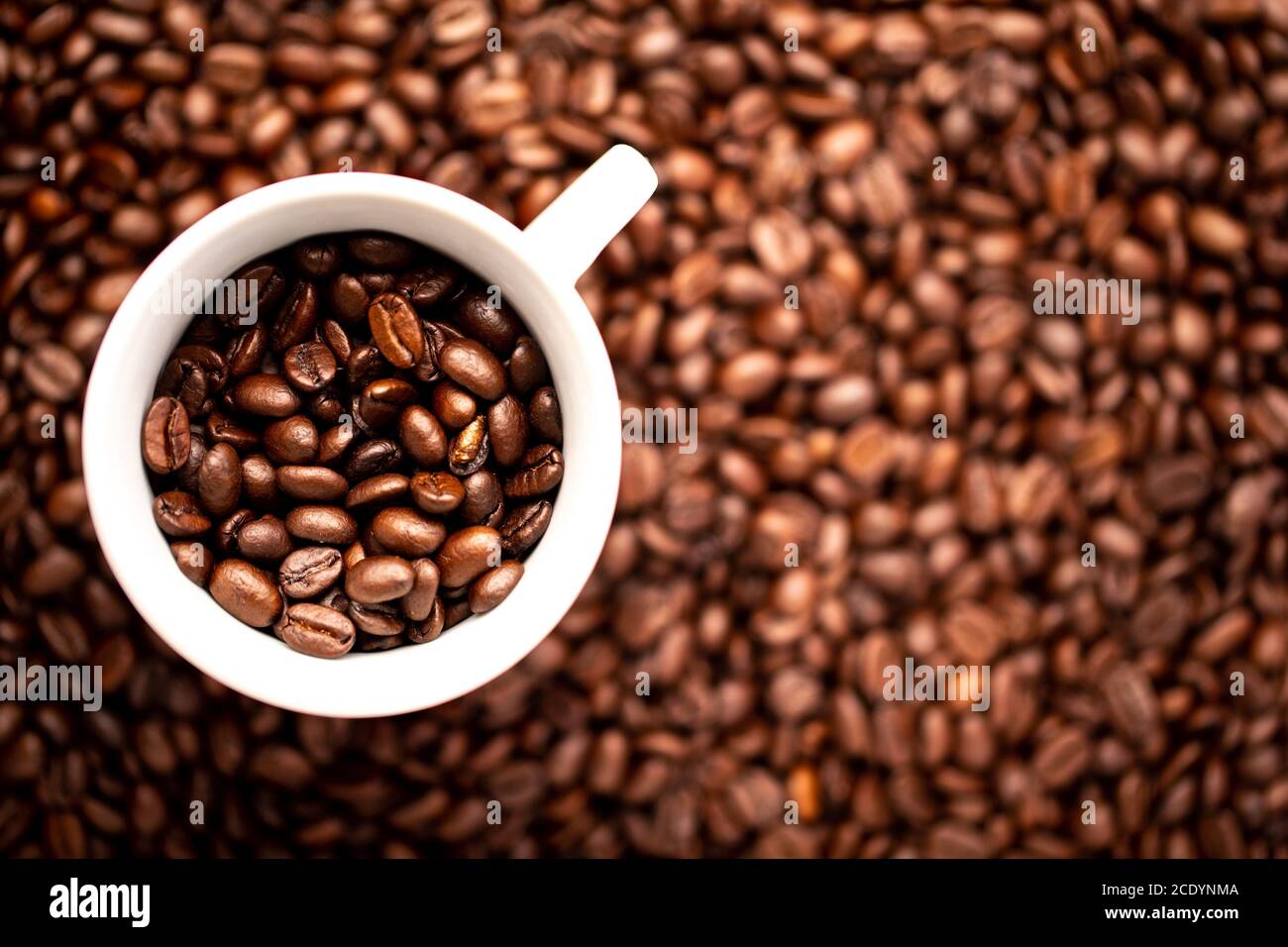 White cup with coffee beans on a background of coffee beans Stock Photo ...