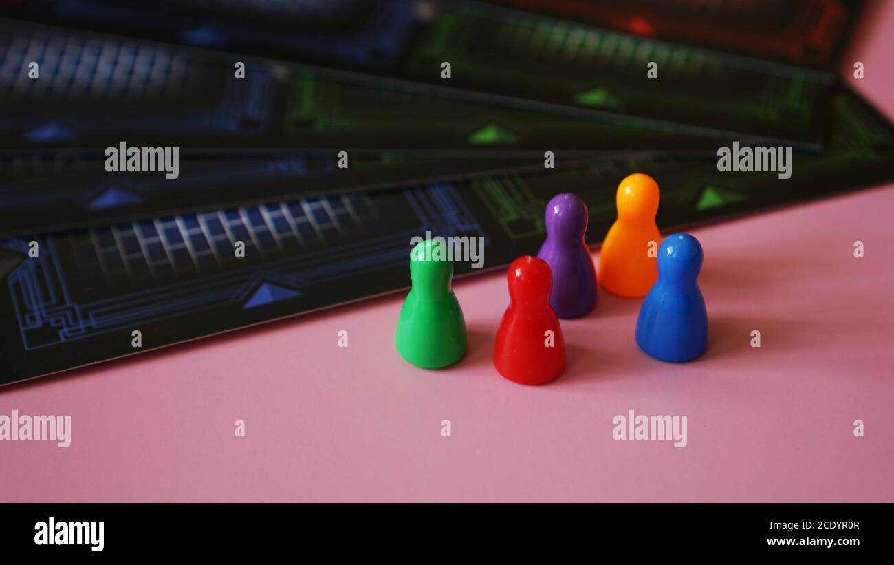 Colored board game figures on pink background Stock Photo - Alamy