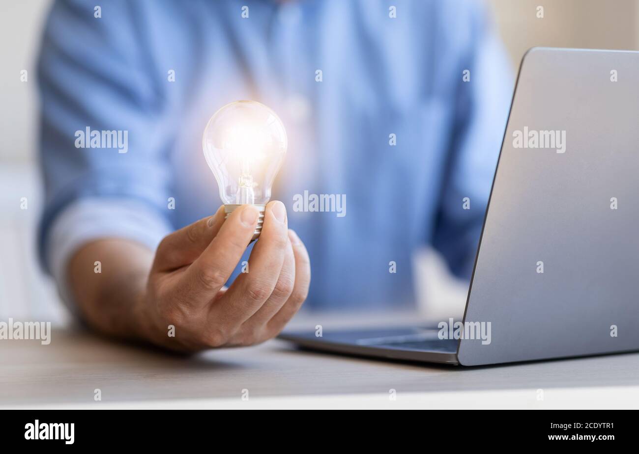 Idea Concept. Unrecognizable businessman holding illuminated light bulb ...