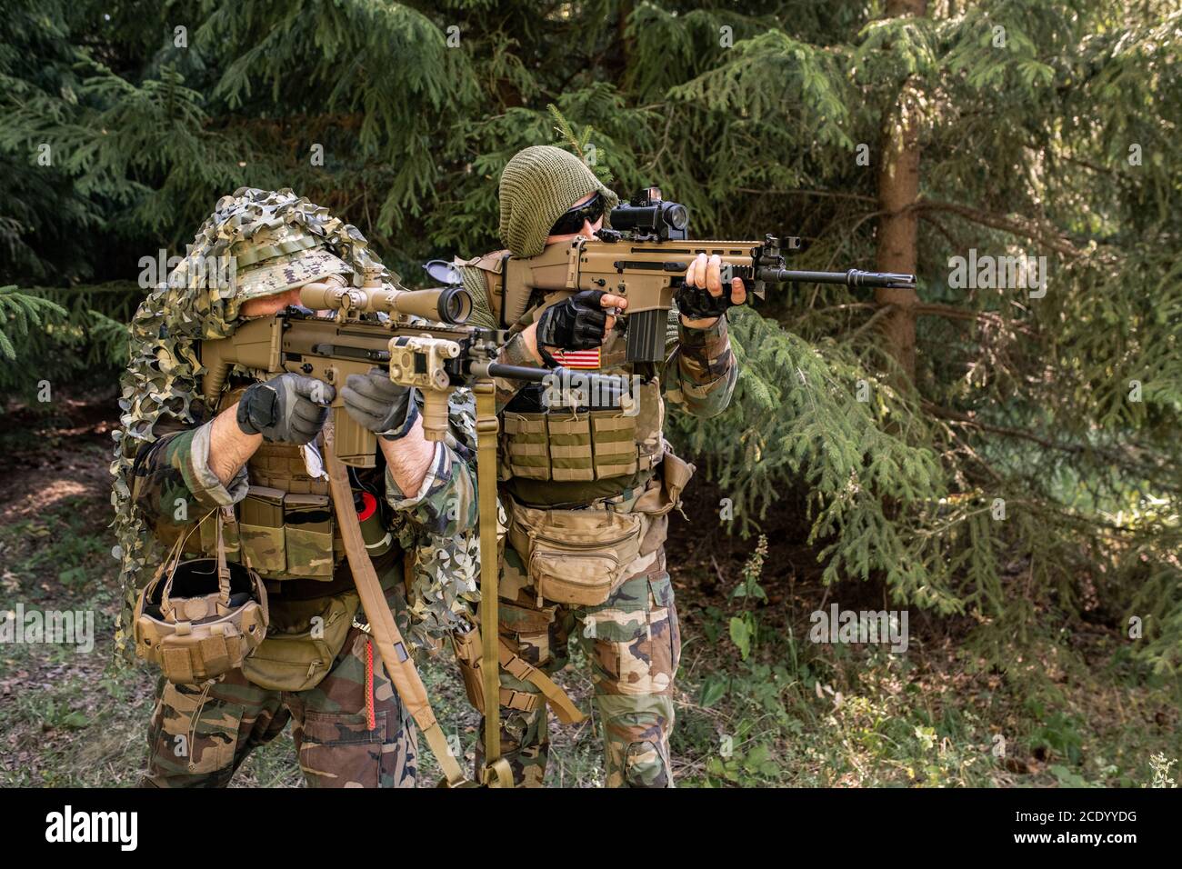 Focused army soldiers in camouflage shooting rifles while neutralizing ...
