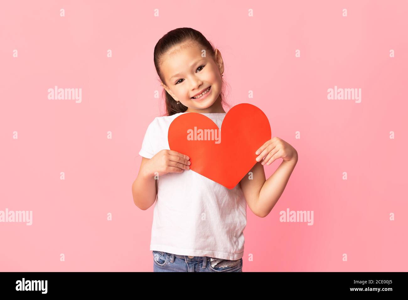 Asian little girl holding paper heart in hands Stock Photo - Alamy