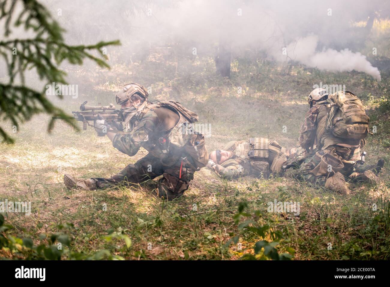 Army soldier shooting rifle while covering colleagues on smoky ...