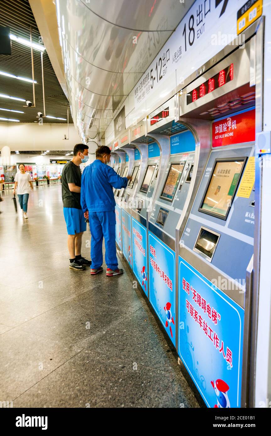 Two men buying subway tickets from a row of machines at Shanghai’s ...