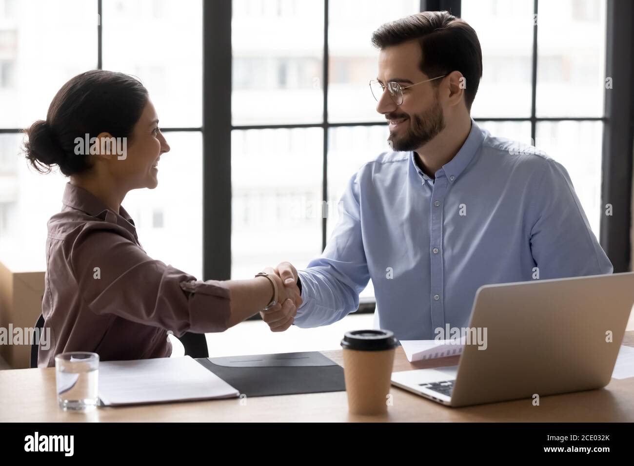 Diverse young business people making agreement in office Stock Photo ...
