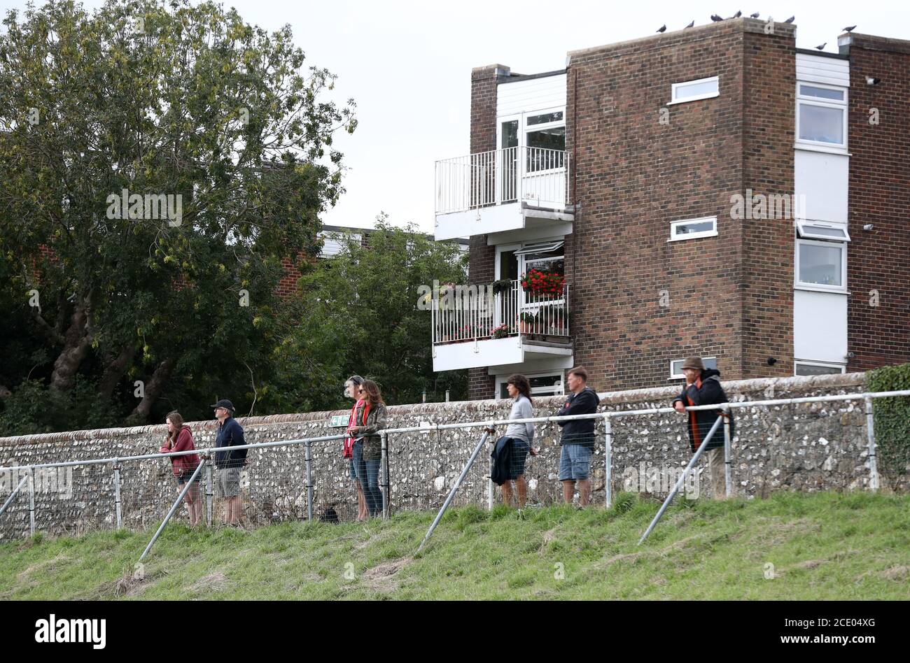 Fans watch from outside the stadium during the pre-season friendly ...