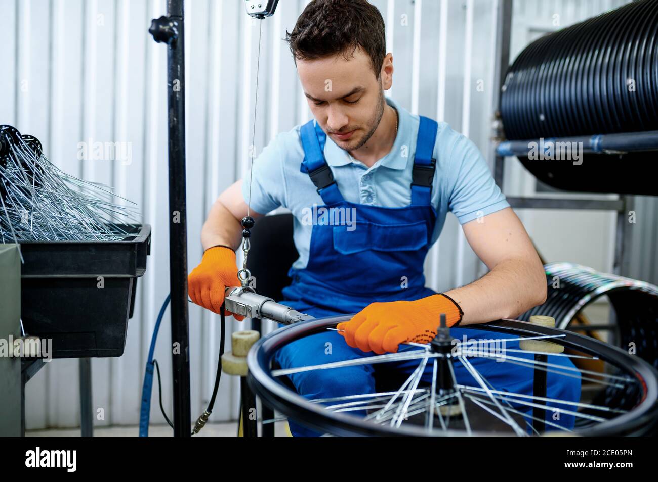 Worker with machine tool installs bicycle spokes Stock Photo - Alamy