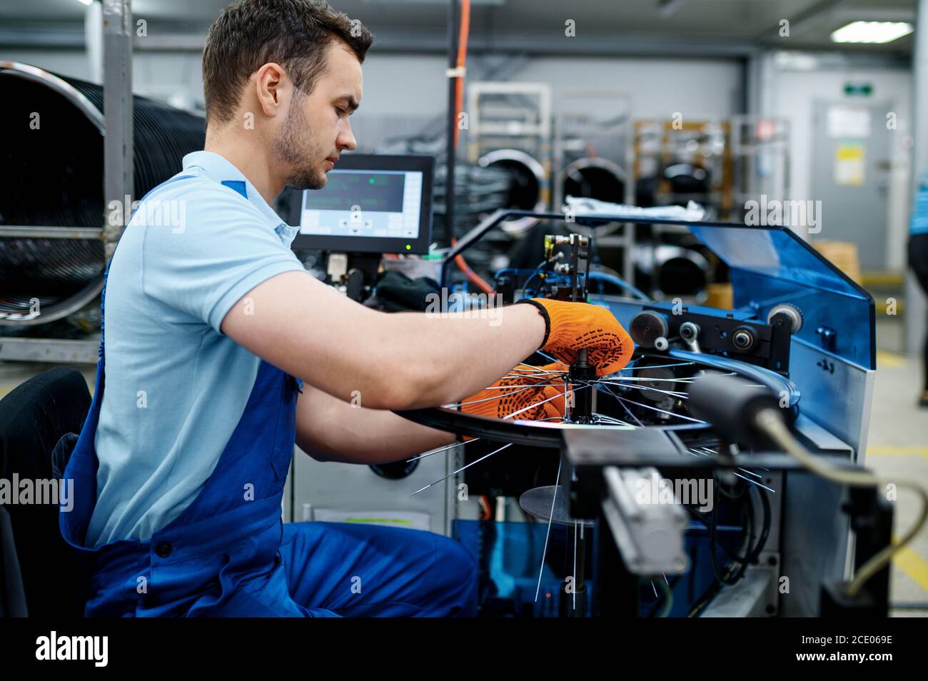 Worker with machine tool installs bicycle spokes Stock Photo - Alamy