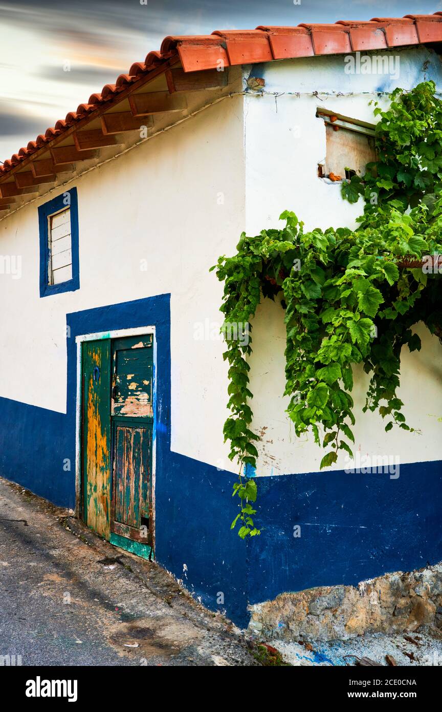White fronted poor house with a badly worn wooden door with a horseshoe ...