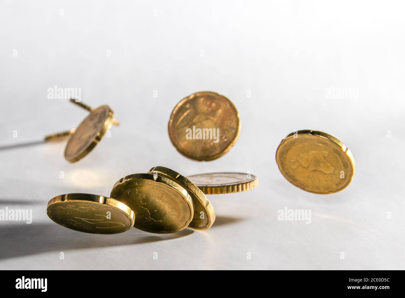 Close-up of coins in motion with white background Stock Photo - Alamy