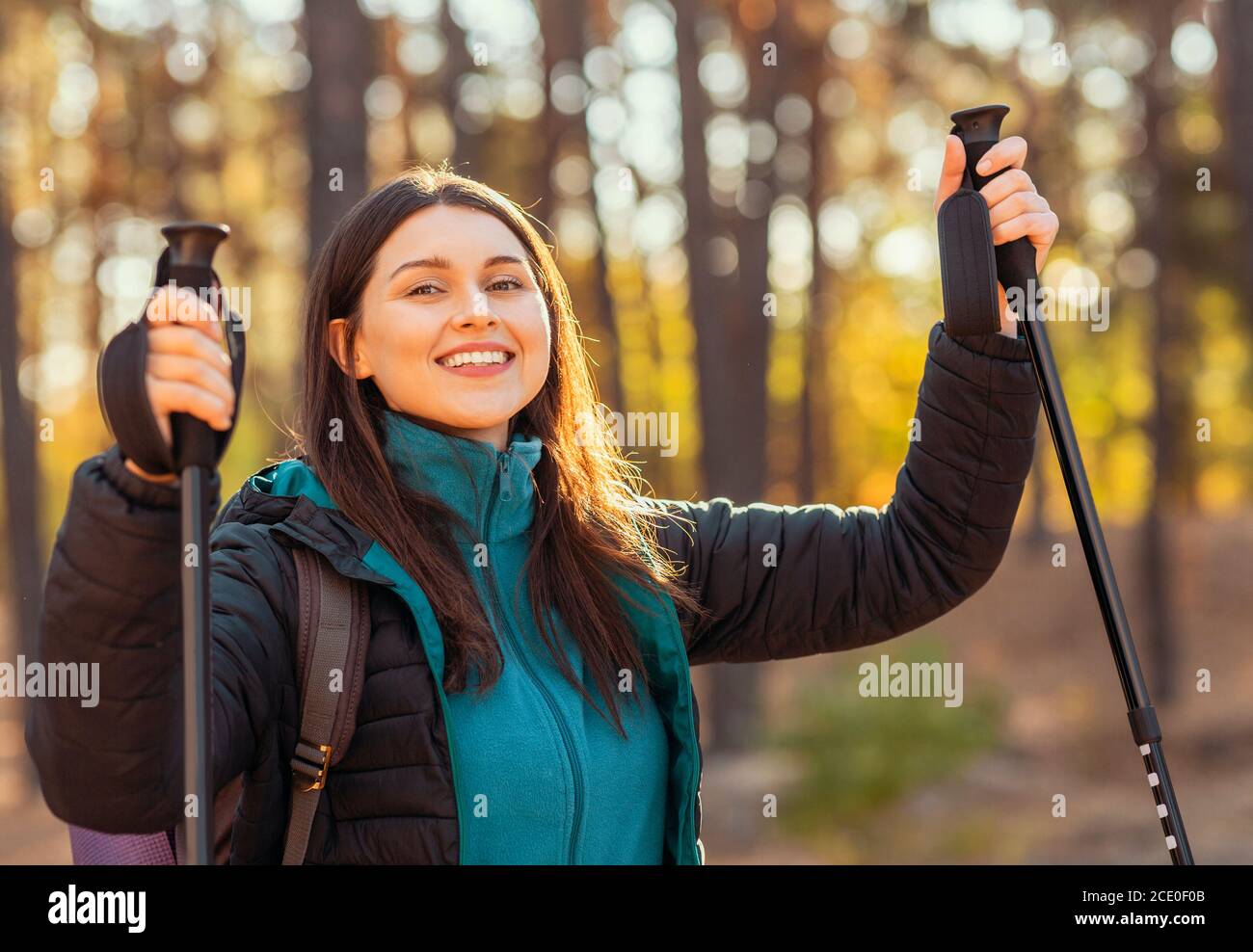 Excited girl with walking sticks posing at forest Stock Photo - Alamy