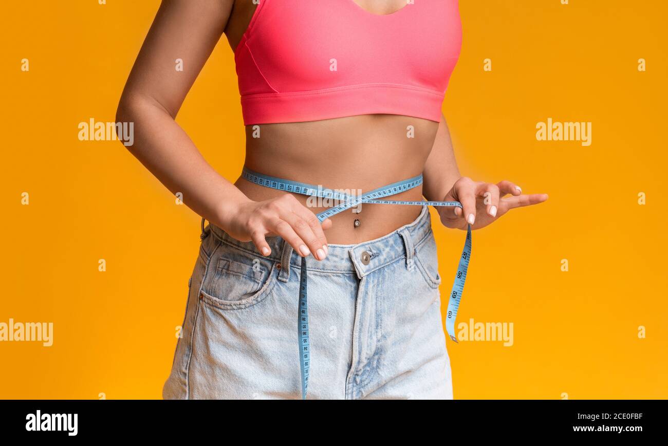 Unrecognizable Fit Female Measuring Waist With Measure Tape Over Yellow ...