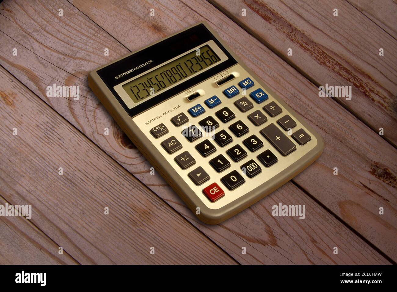 LED display electronic calculator on wooden background. Battery-powered ...