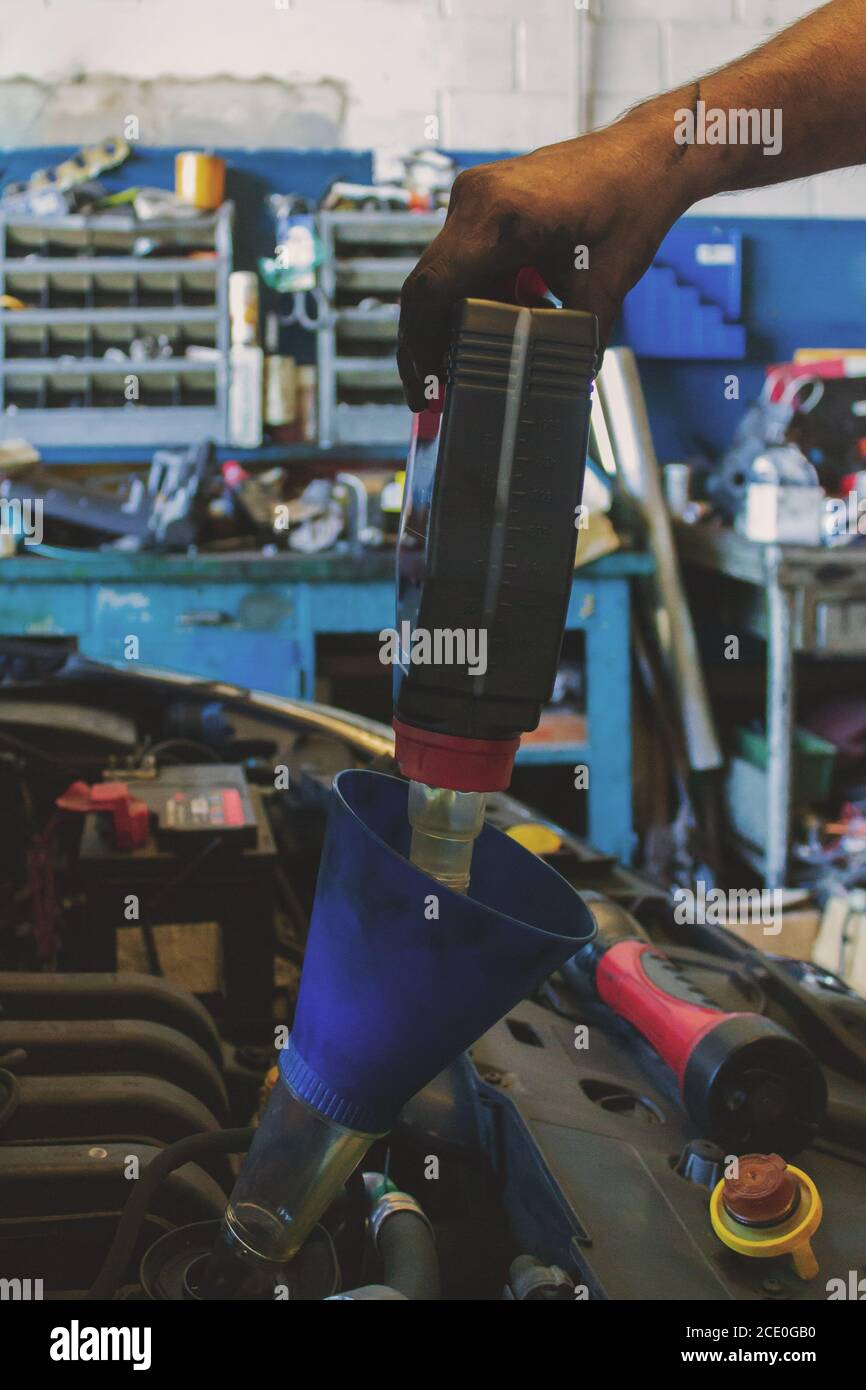 Professional car mechanic refilling engine oil Stock Photo - Alamy