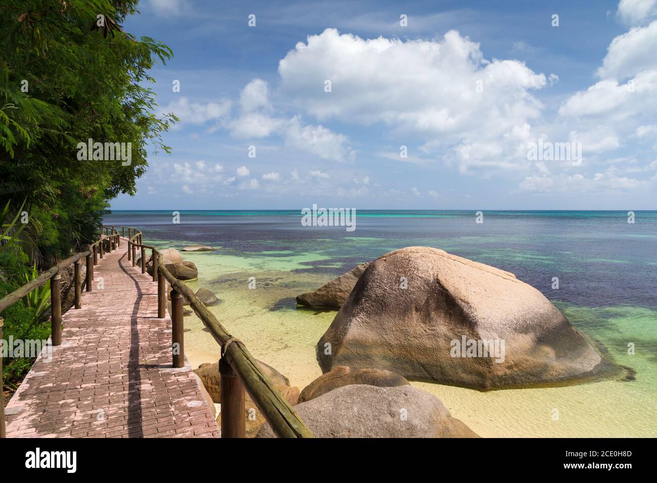 Pathway by the ocean with big stones and green plants Stock Photo - Alamy