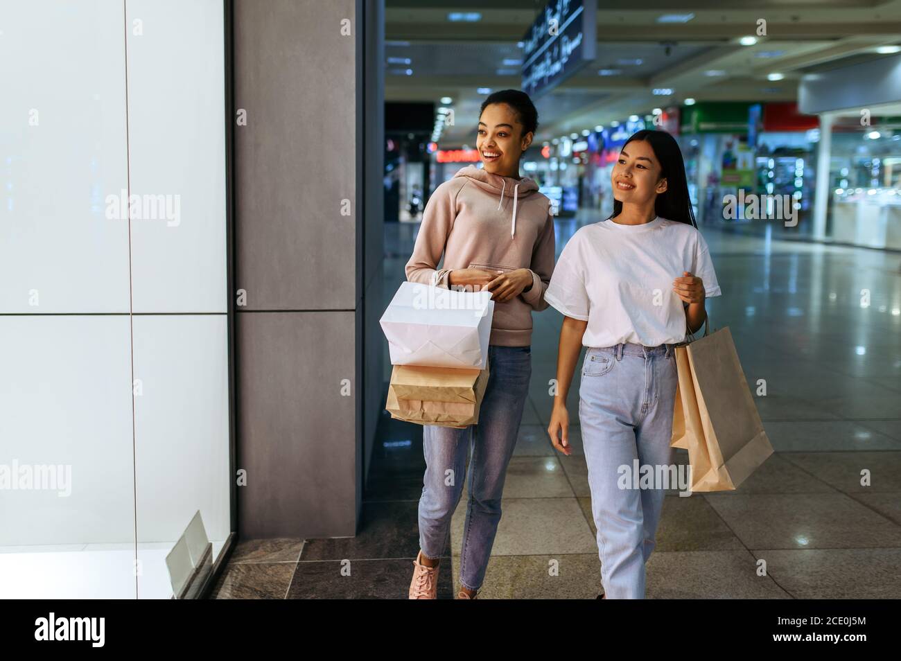 Girls with bags at the showcase in clothing store Stock Photo - Alamy