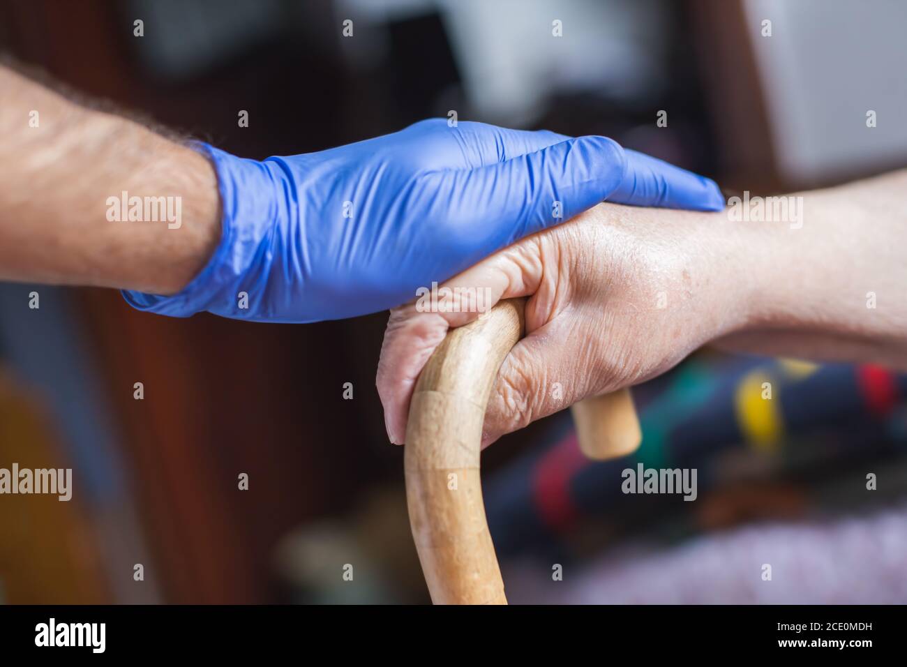 gloved hand on elderly person's hand holding a walking stick Stock ...