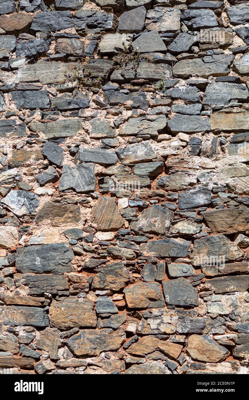 View of a rustic and old schist exterior wall, architectural textures ...