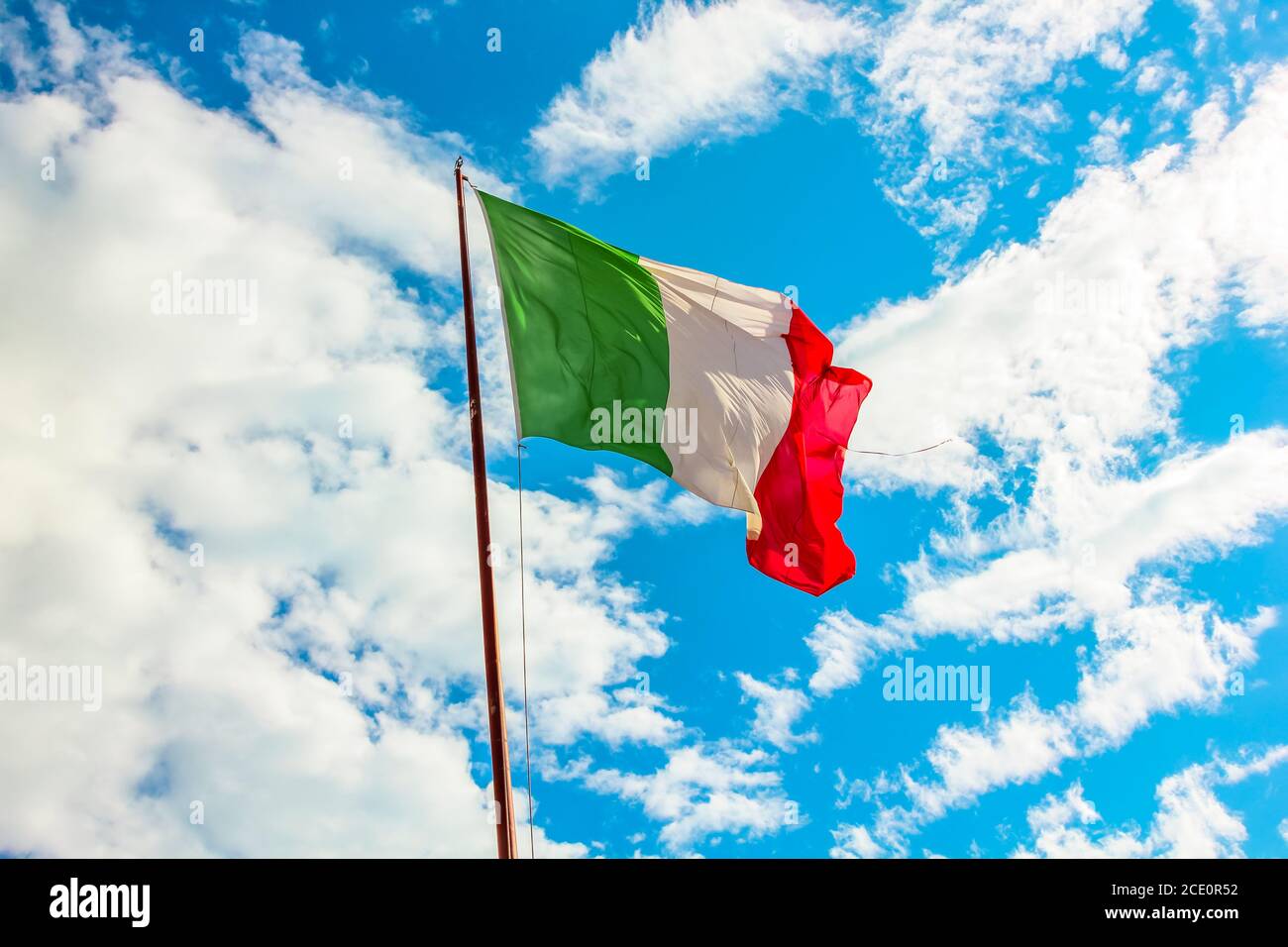Italy flag waving on blue cloudy sky, green white and red colors ...