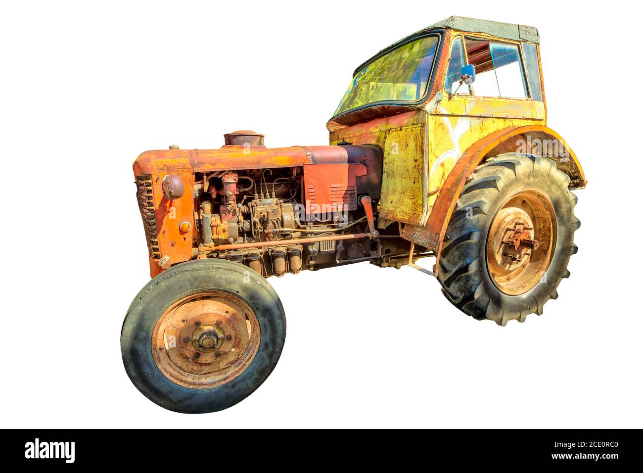 Side view of an old yellow vintage tractor with broken wheel abandoned ...