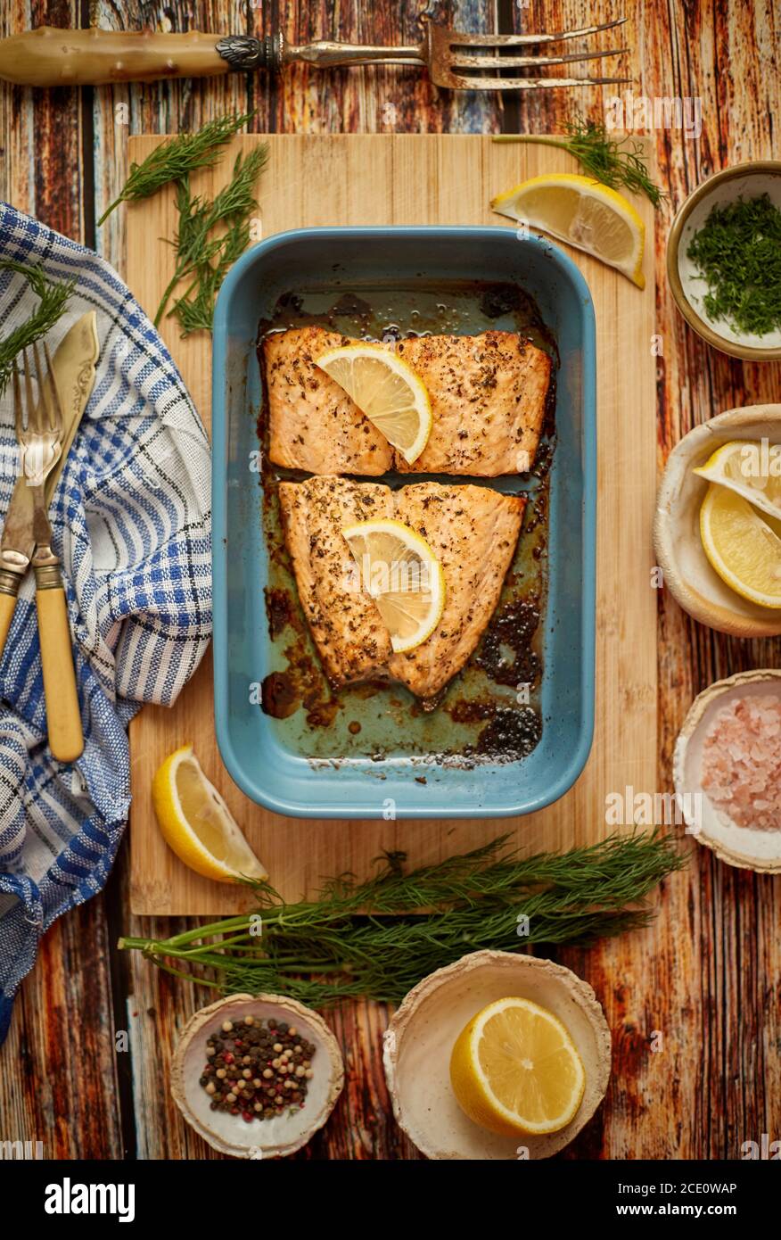 Roasted salmon in heat proof dish. With aromatic dill, lemon, salt and ...