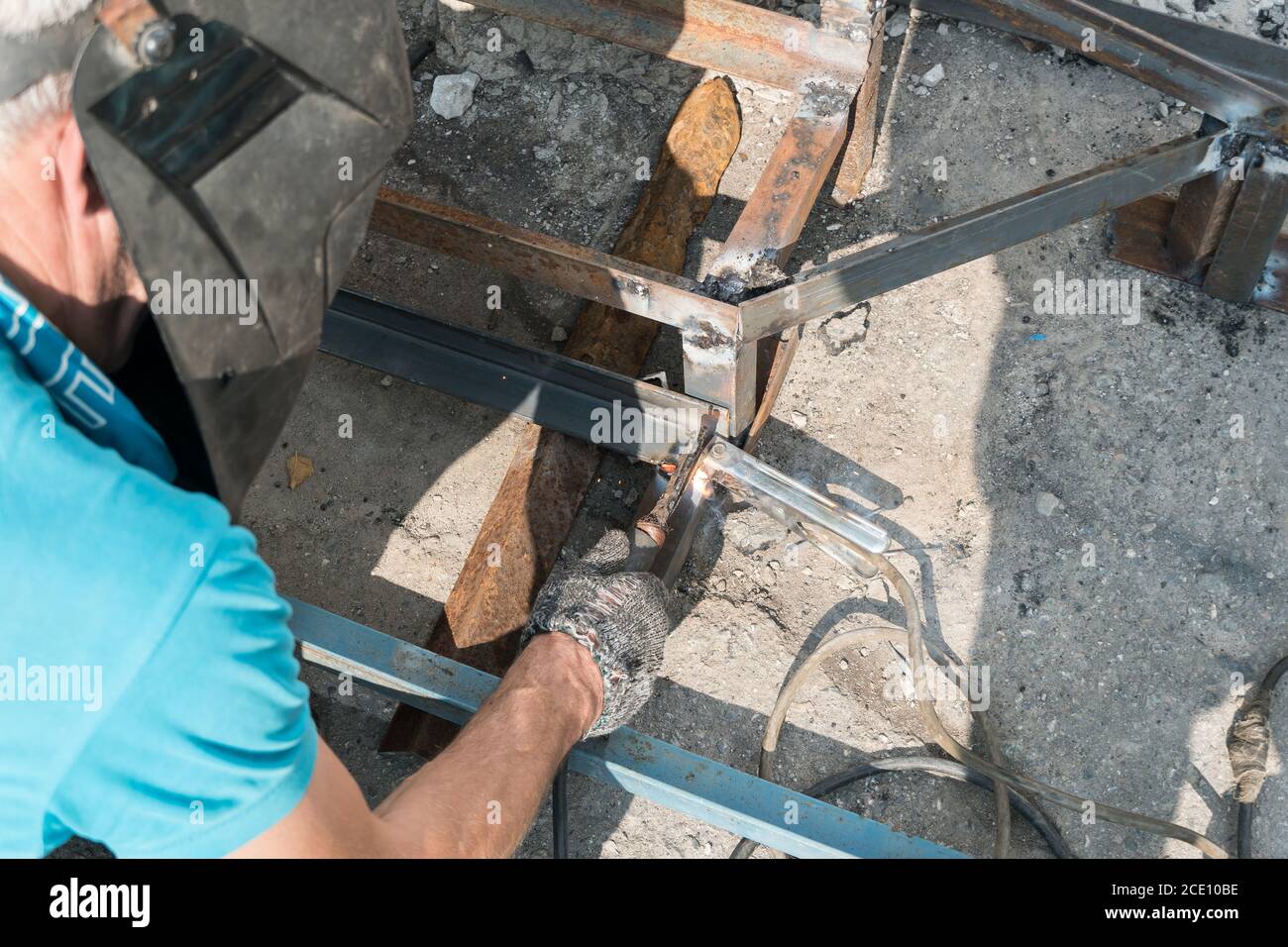 A working welder builds or repairs a new porch and facade of a building ...