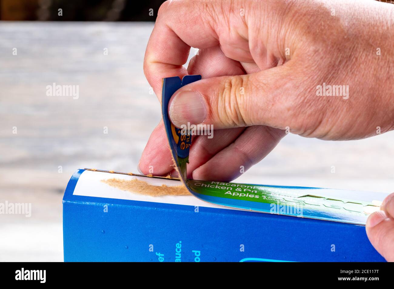 Tearing tab off of a box of a frozen dinner Stock Photo - Alamy