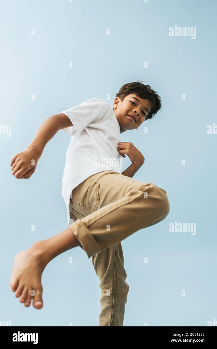Showing off indian asian kid doing side kick with his foot, bending ...